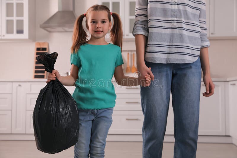 Little Girl Holding Bin Bag Full of Garbage in Kitchen Stock Photo ...
