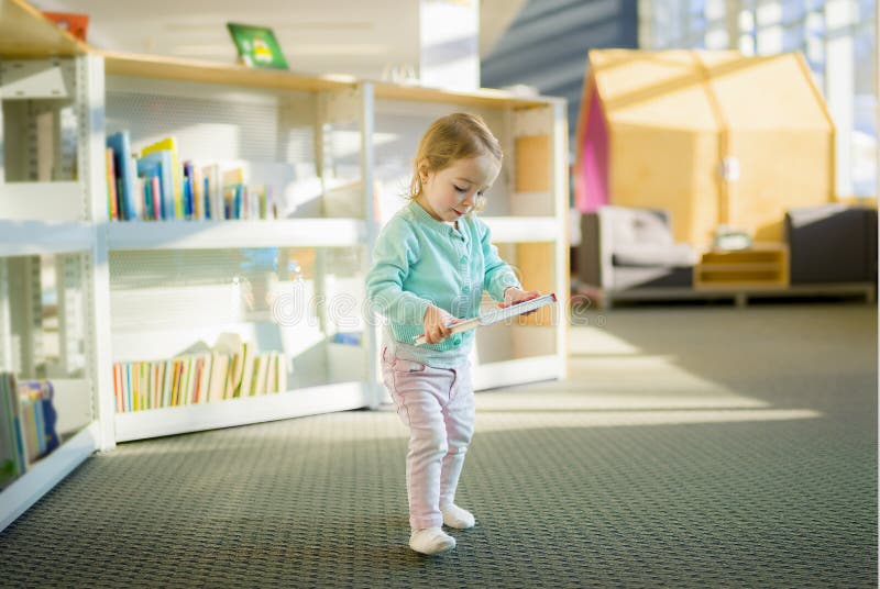 Little Girl Holding Books at the Library Stock Photo - Image of smile ...