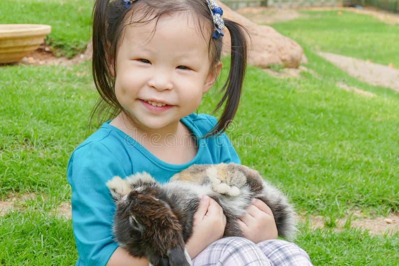Little Girl Holding Rabbit in Park Stock Image - Image of care, chinese ...