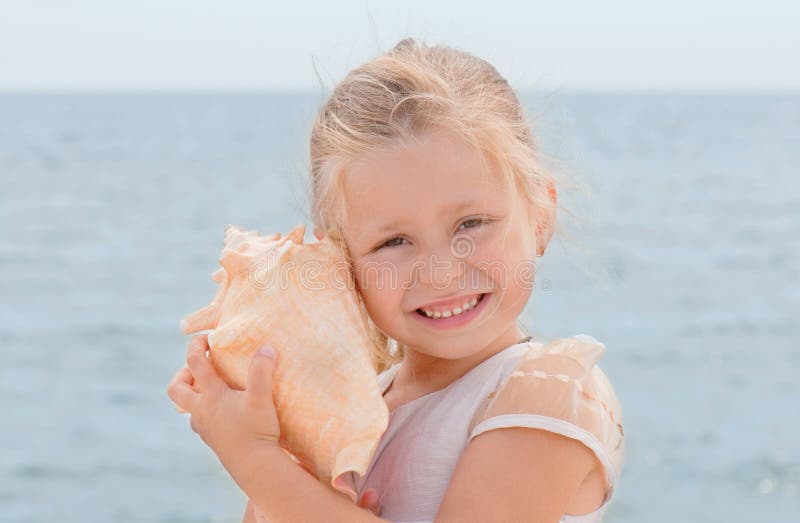 Little girl holds a shell stock photo. Image of blond - 11099062