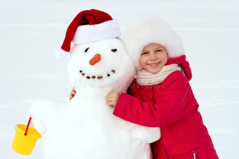 Little Girl Hugging a Snowman and Laughs. Winter Fun Stock Photo ...