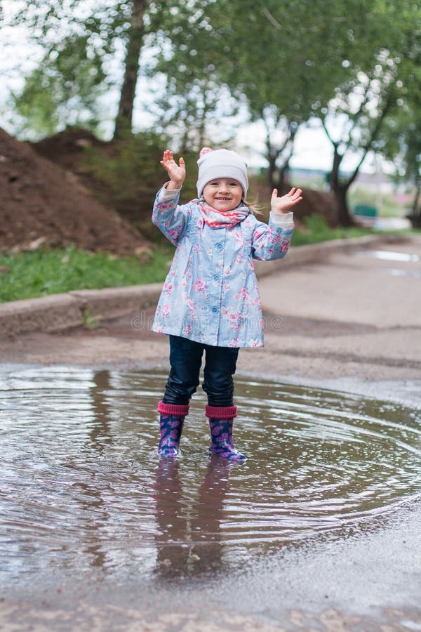 Little Girl Jumping in the Puddle Stock Photo - Image of emotions, play ...