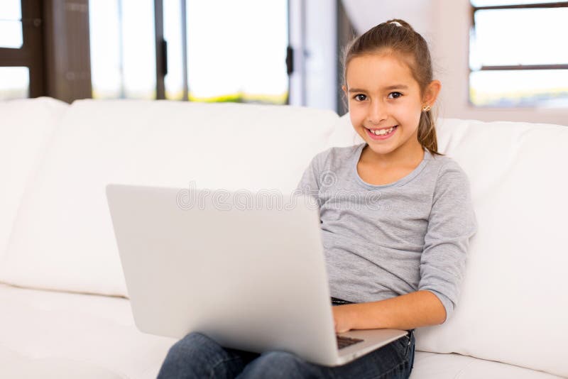 Little girl laptop sofa stock photo. Image of looking - 64107396