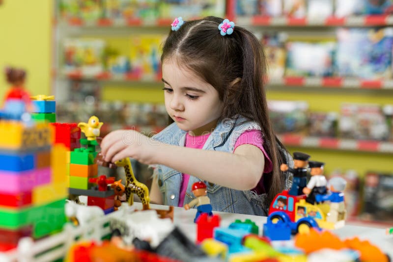 Little Girl Playing with Building Blocks in the Store. Stock Photo ...
