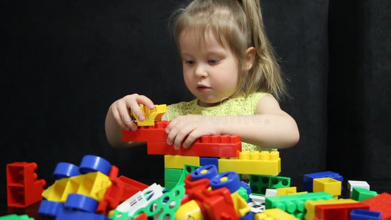 3 Years Old Girl Playing with Coloured Blocks of a Constructor. the ...