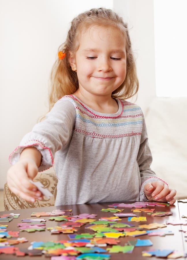Little girl playing puzzle stock photo. Image of home - 65208264