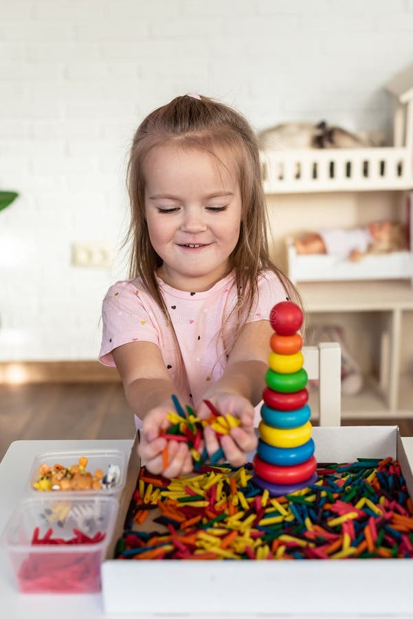 A Little Girl Playing with Sensory Bin with Dyed Pasta for Play and ... A Little Girl Playing with Sensory Bin with Dyed Pasta for Play and ...