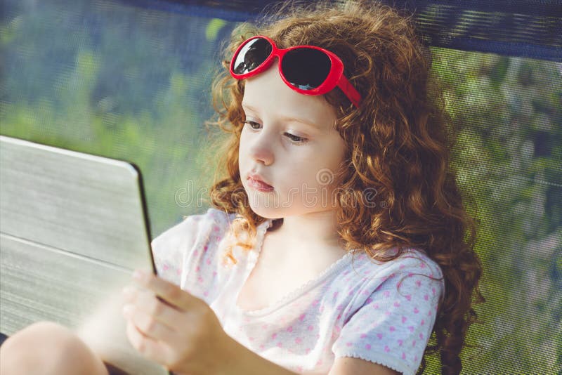 Little Girl Playing Tablet Pc on Outdoors. Stock Image - Image of ...