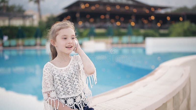 Little Girl by the Pool Talking on the Phone Stock Footage - Video of ...