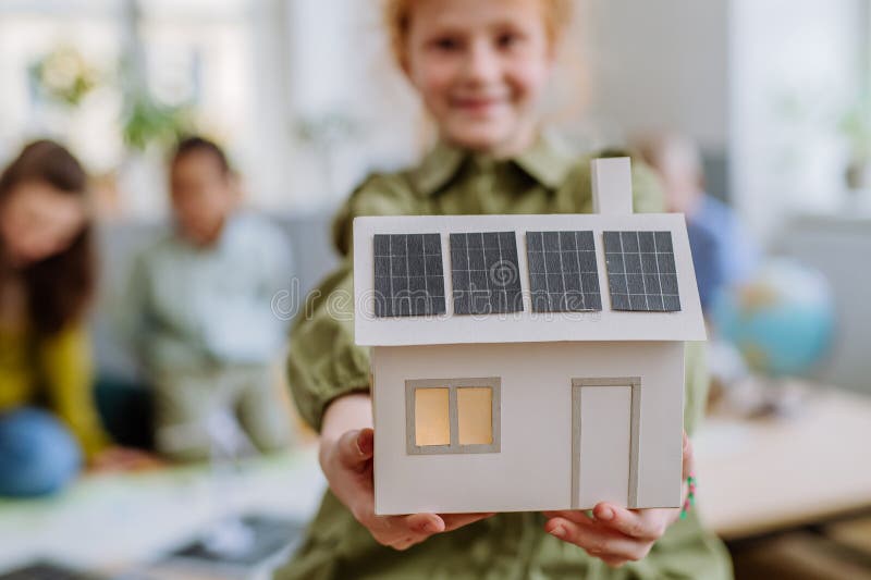Little Girl Posing with Model of House with Solar System during a ...