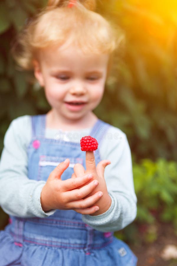 Raspberry on Fingers of a Little Girl Stock Image - Image of shoulders ...