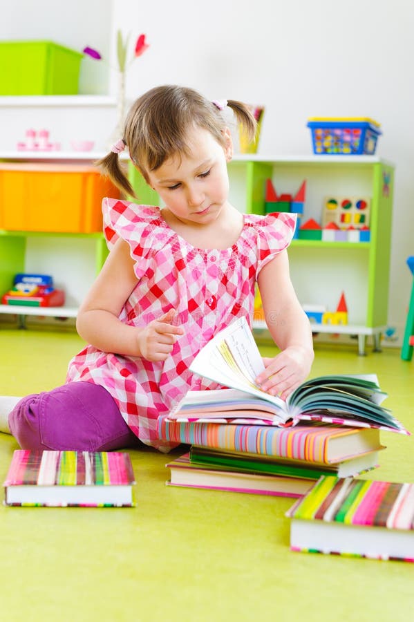 Little Girl Reading Book on Floor Stock Photo - Image of child, green ...