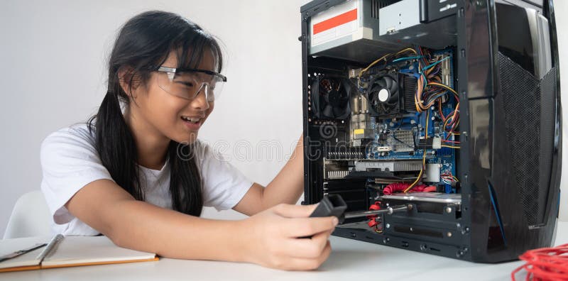 A Little Girl is Repairing Computer Hardware at the White Working Table ...