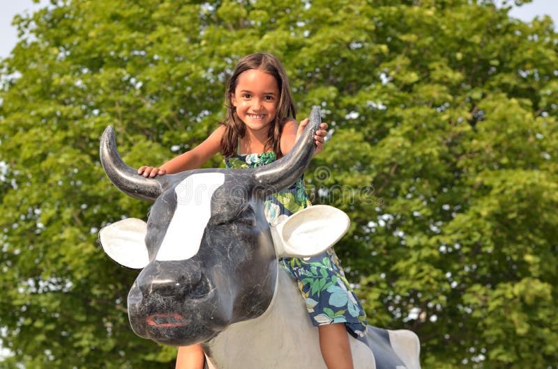 Little Girl Riding Cow Sculpture Stock Image - Image of vacation ...