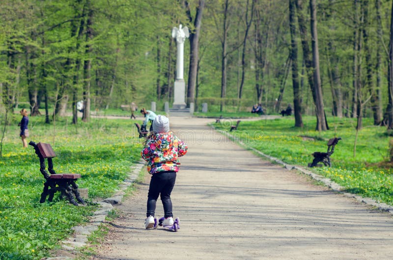 Little Girl Riding a Scooter in the Spring Park Stock Image - Image of ...