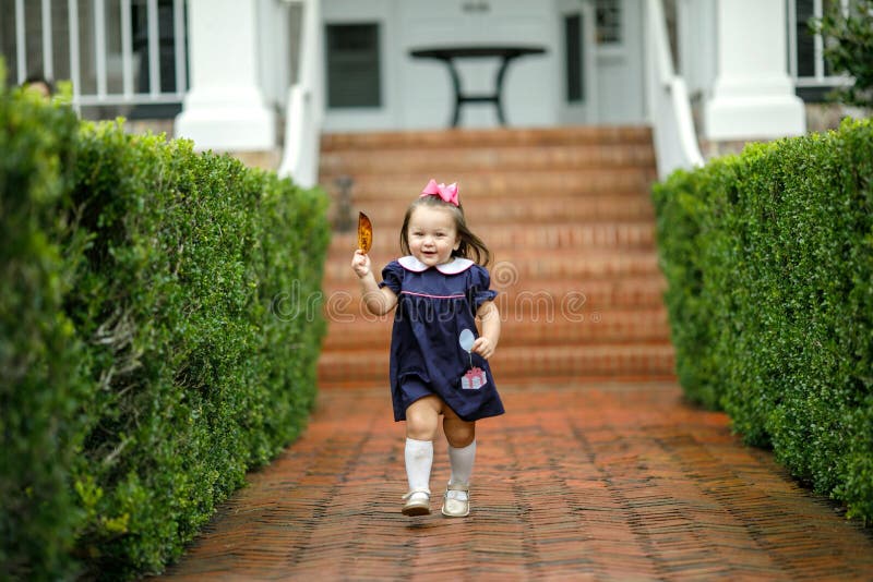 A Little Girl Running Down a Brick Walkway Path Stock Image - Image of ...