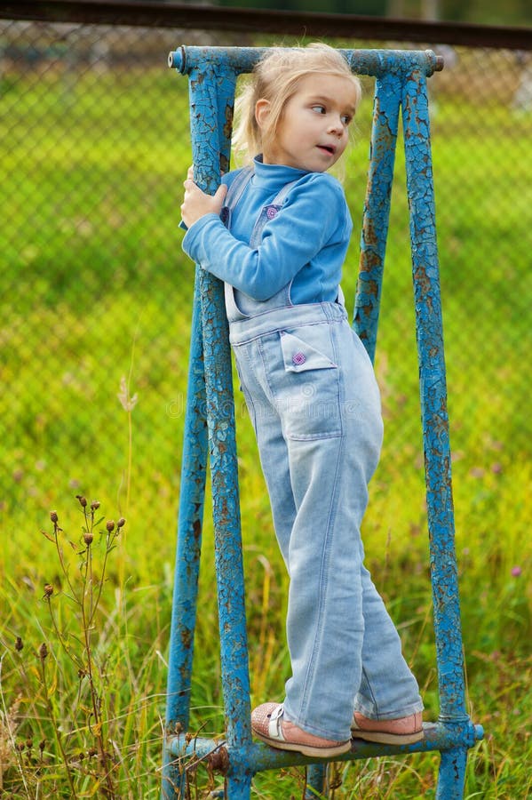 Little Girl on Rusty Blue Gymnastic Stock Image - Image of look, arms ...