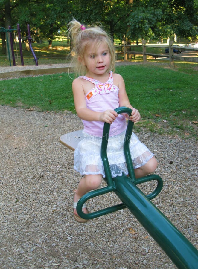 Little Girl on See-Saw stock photo. Image of playground - 3289590