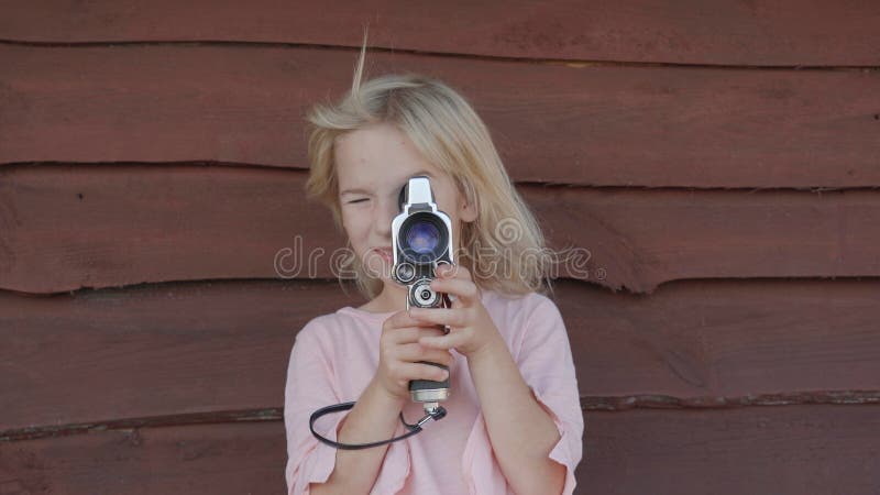 A Little Girl Shoots a Video of an Old Retro Camera. Stock Image ...