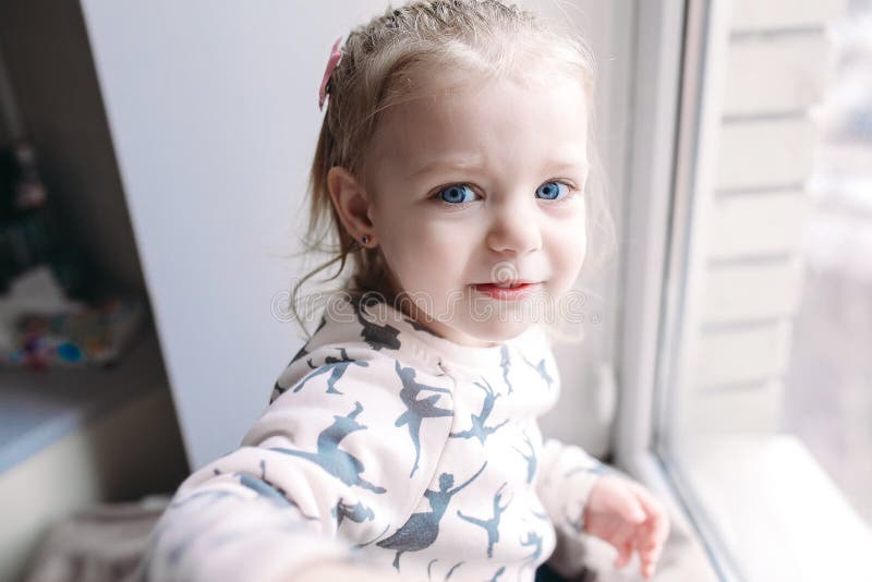 Little Girl Sitting Near the Window Stock Photo - Image of holding ...