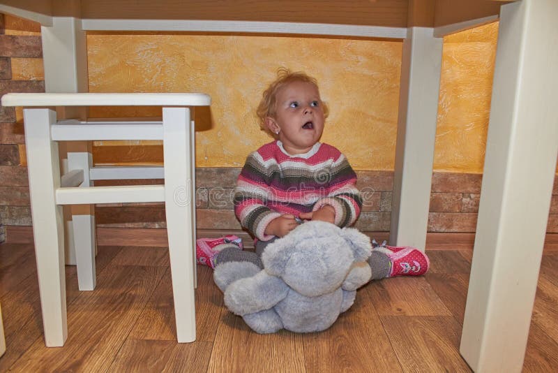 A Little Girl is Sitting Under the Table,the Child Hid in the Kitchen ...