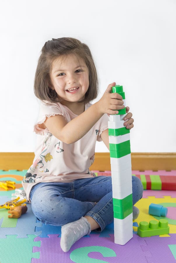 Little Girl Smiling and Playing with Colorful Toy Blocks. Construction ... Little Girl Smiling and Playing with Colorful Toy Blocks. Construction ...