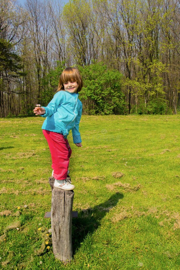 Little Girl Standing on the Big Log in the Park Stock Image - Image of ...