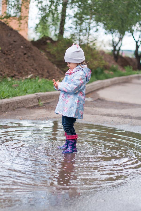 Little Girl Jumping in the Puddle Stock Photo - Image of emotions, play ...