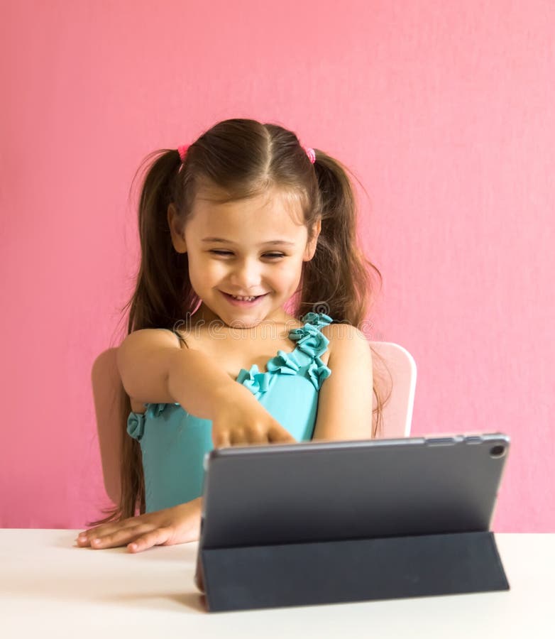 Little Girl with a Tablet at the Table Stock Photo - Image of happy ...