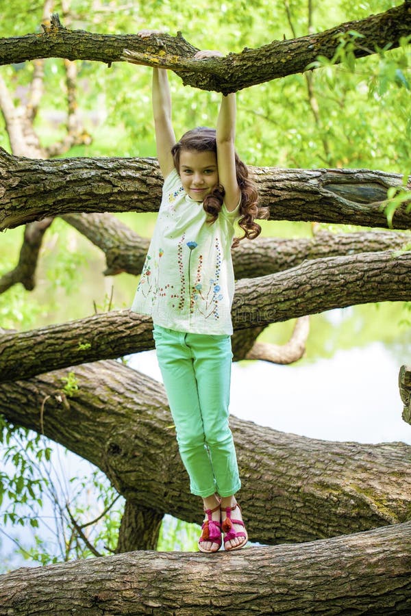 Little Girl on tree trunk stock image. Image of beautiful - 74459211