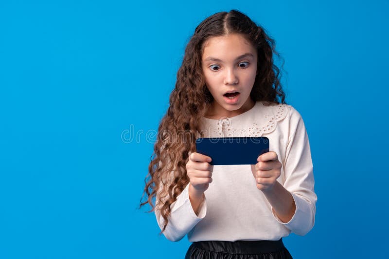 Little Girl Using Mobile Phone.against Blue Background Stock Image ...