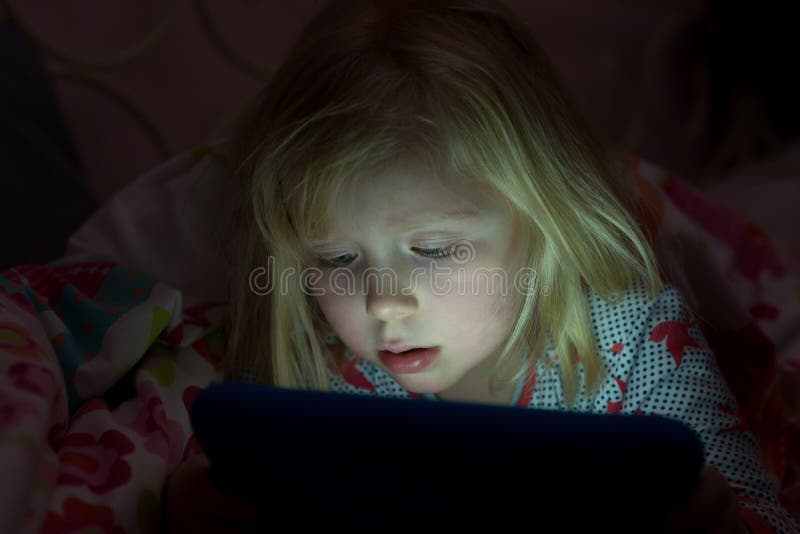 LIttle Girl Using a Tablet in a Dark Room Stock Image - Image of ...