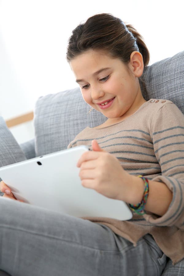 Little Girl Using Tablet on Sofa Stock Photo - Image of couch, digital ...