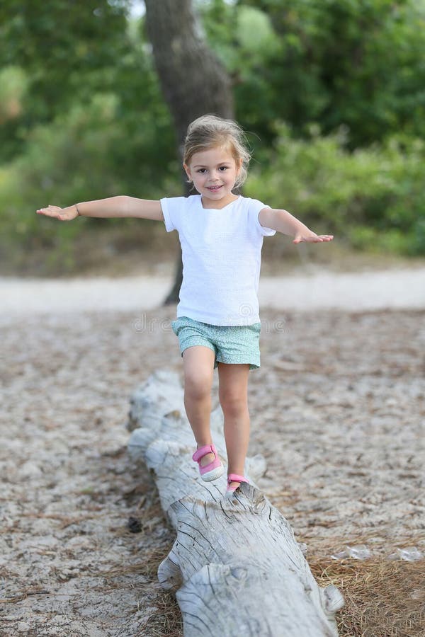 Little Girl Walking on Tree Trunk Stock Image - Image of tree, enjoying ...