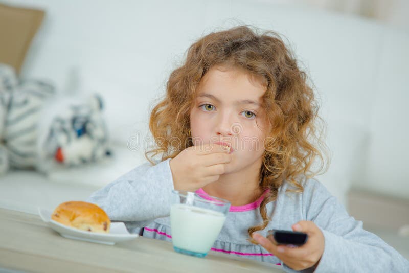 Little Girl Watching TV As she Has Breakfast Stock Photo - Image of ...