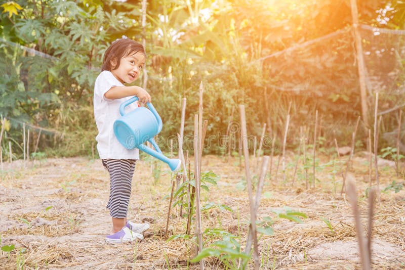 Little Girl Watering Tree with Watering Pot Stock Photo - Image of ...