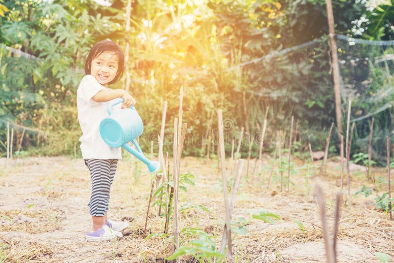 Little Girl Watering Tree with Watering Pot Stock Image - Image of ...