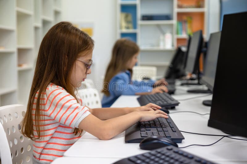 Little Girl Working on Computer in School Library. Stock Photo - Image ...