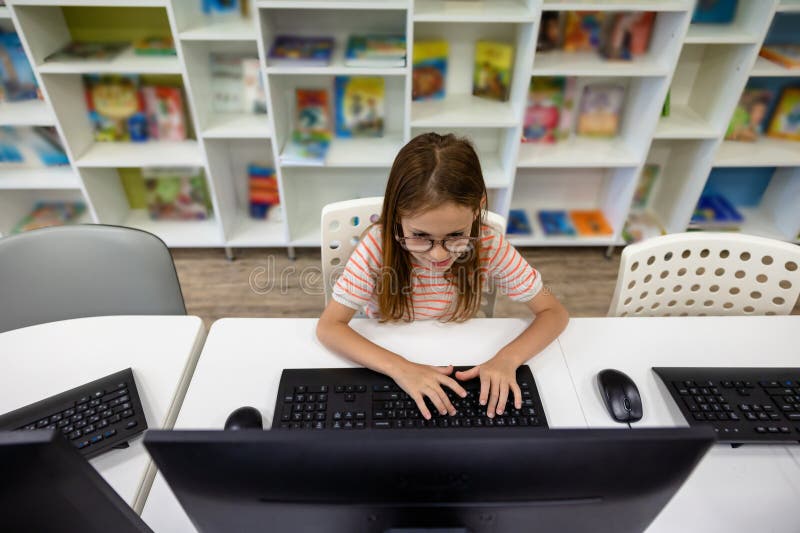 Little Girl Working on Computer in School Library. Stock Image - Image ...