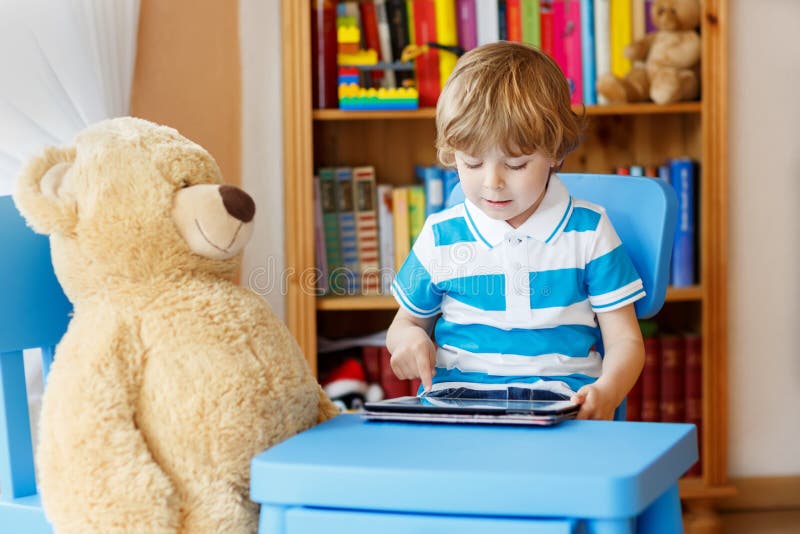 Little Kid Boy Playing with Tablet Computer in His Room at Home Stock ...