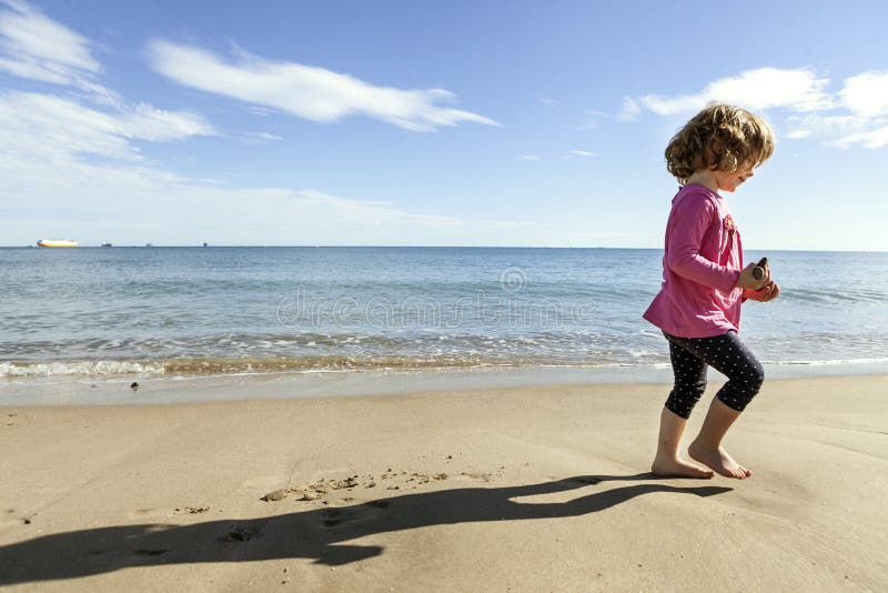 Little Kid Playing in the Beach with a Big Shadow Stock Image - Image ...