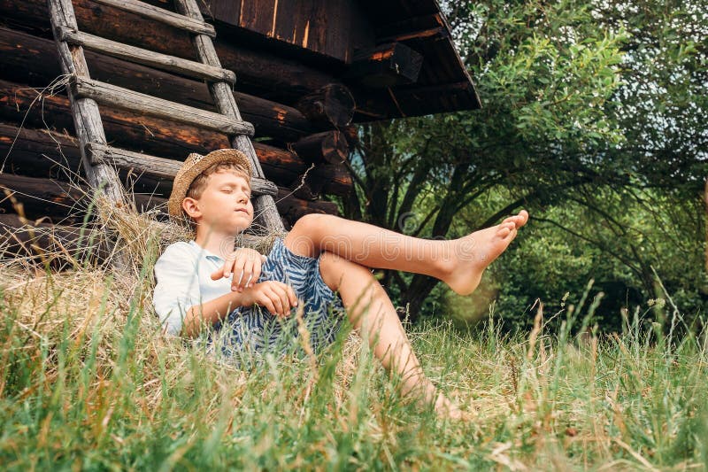 Barefoot Boy Sleeps On The Grass Near Ladder In Haystack Stock Photo ... Barefoot Boy Sleeps On The Grass Near Ladder In Haystack Stock Photo ...