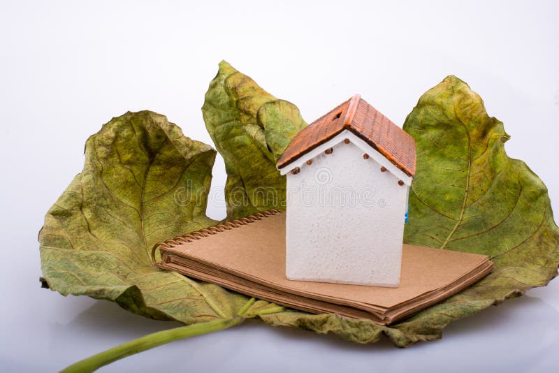 Little Model House Placed on an Autumn Leaf and a Notebook Stock Image ...