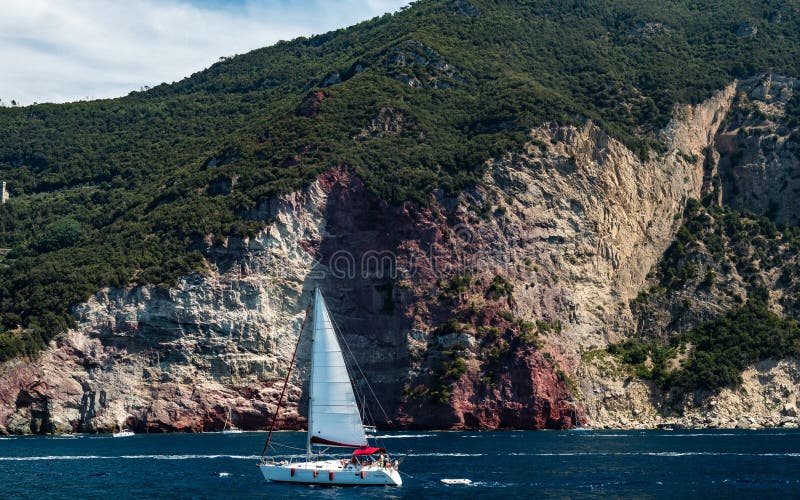 Little Sailing Ship in Front of Red Cliff at Coast Stock Photo - Image ...