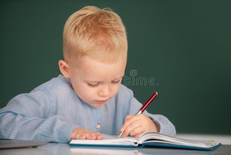 Little Schoolboy Study in a Classroom at Elementary School. Kid Writing ...