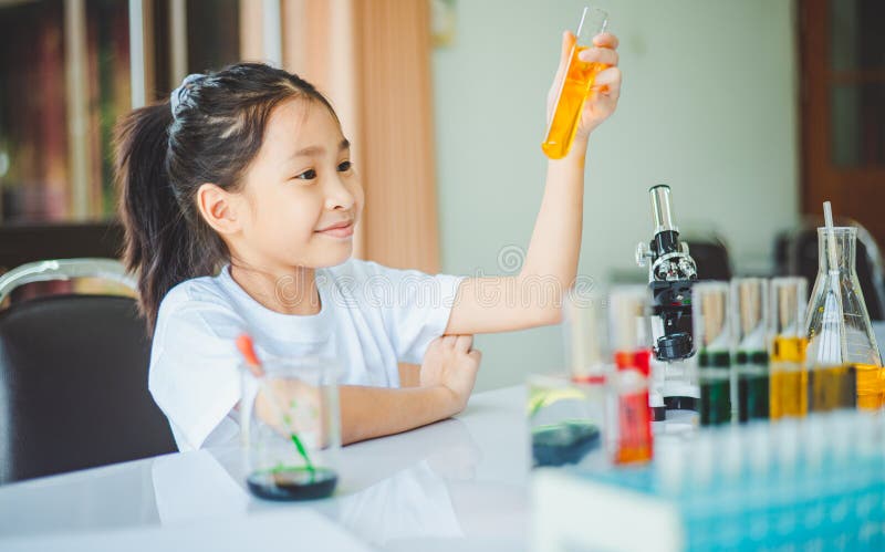 Little Scientist Looking through a Microscope and Test Tubes Filled ...