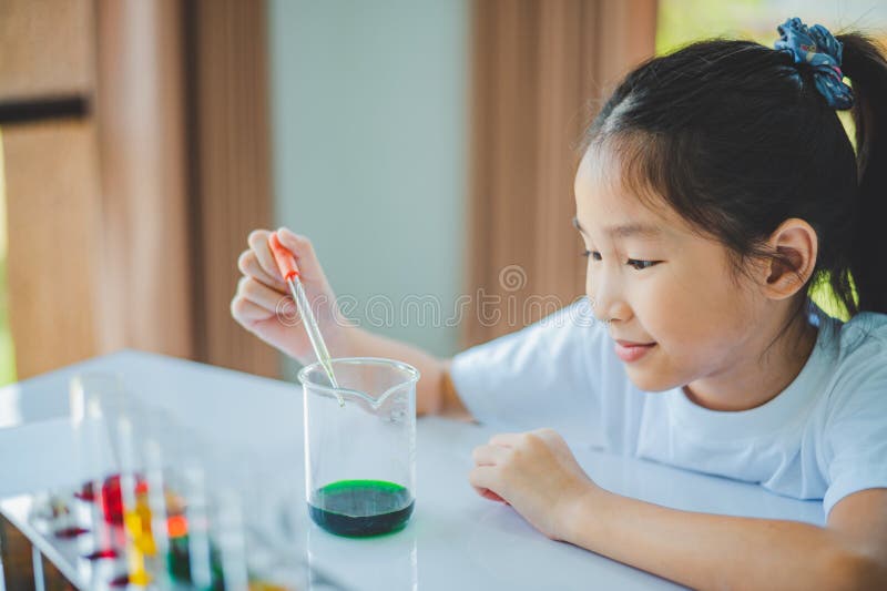 Little Scientist Looking through a Microscope and Test Tubes Filled ...