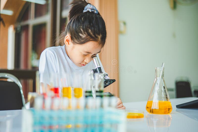 Little Scientist Looking through a Microscope and Test Tubes Filled ...
