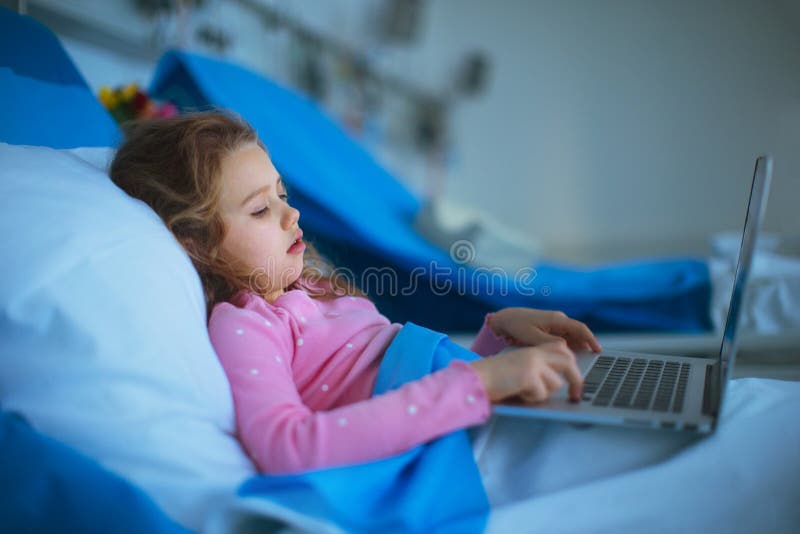 Little Sick Girl Lying at Hospital Bed and Using Laptop. Stock Image ...