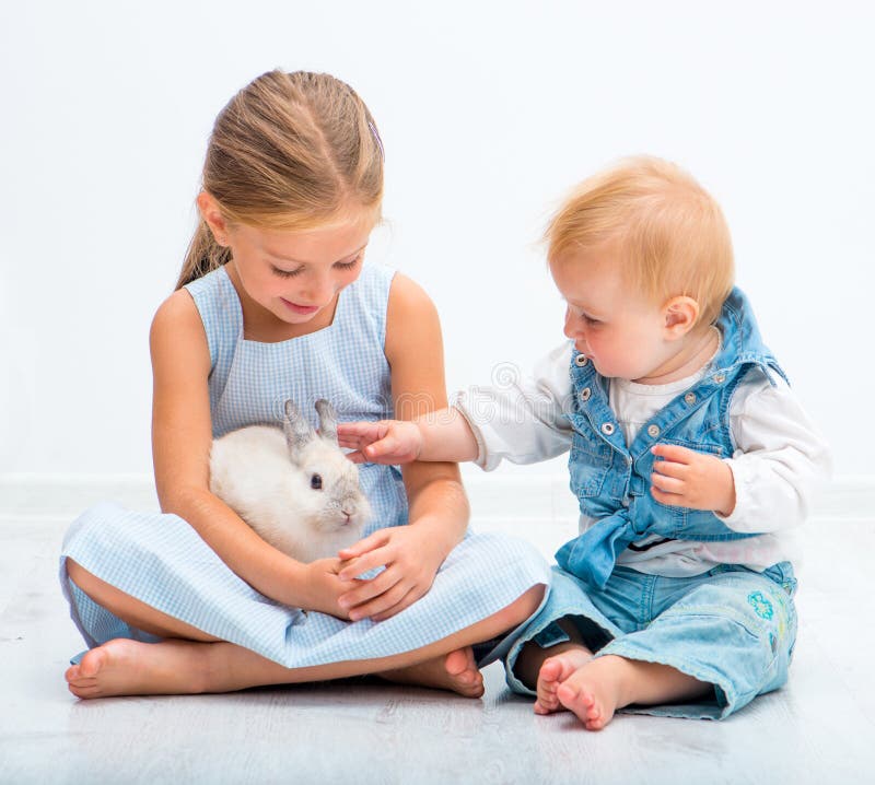 Little Sisters with a Rabbit Stock Photo - Image of spring, caucasian ...